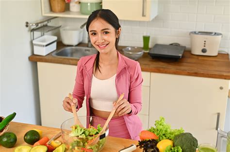 부엌 식탁에서 야채 샐러드를 준비하는 아름다운 젊은 여자 건강한 라이프스타일과 채식 음식 개념 25 29세에 대한 스톡 사진 및