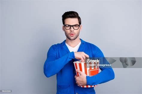 팝콘 영화에 대 한 열정 양동이 들고 안경에 집중된 남자의 회색 배경에 고립 된 블루 카디 건 입고 남자 사업가에 대한 스톡 사진 및 기타 이미지 Istock