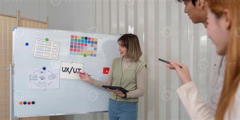 Creative Ux Developer And Ui Designer Brainstorming Session In Modern Office With Whiteboard And