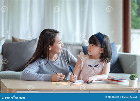 Madre Asiatica Che Insegna A Sua Figlia Carina A Studiare In Soggiorno Immagine Stock Immagine