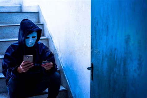 hacker wearing a white mask in front of his computer hacker hacks