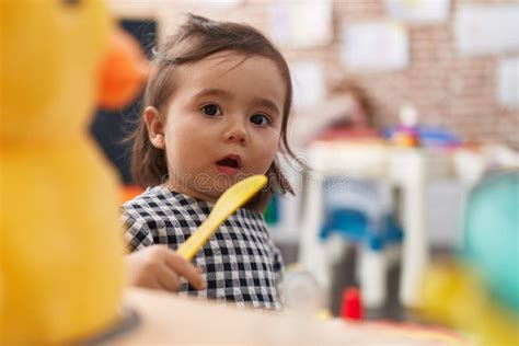 Adorable Chinese Girl Playing With Play Kitchen Holding Knife Toy At