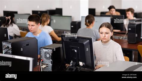 Interested Teen Girl Studying With Classmates In School Class Stock