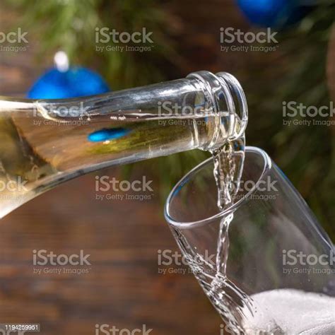 샴페인 한 병이 크리스마스 장식의 배경에 거품이 있는 공에 부어 넣습니다 아름다운 인사말 카드입니다 12월에 대한 스톡 사진 및 기타 이미지 Istock