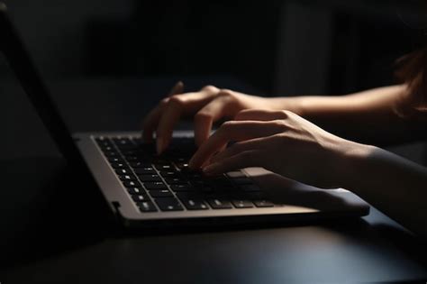 Premium Ai Image A Person Typing On A Laptop Keyboard In The Dark