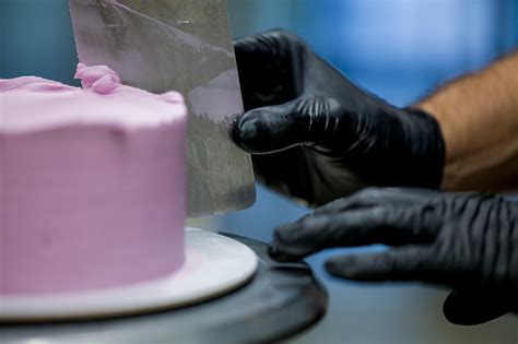 주걱과 스크레이퍼를 사용하는 데코레이터 스무딩 라일락 버터 크림 생일 젖빛 케이크 케이크 장식하기에 대한 스톡 사진 및 기타