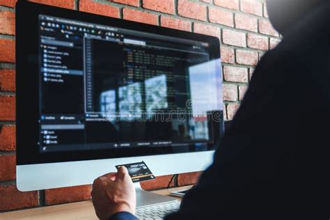 Dangerous Hooded Hacker Using Credit Card Typing Bad Data Into Computer Online System And
