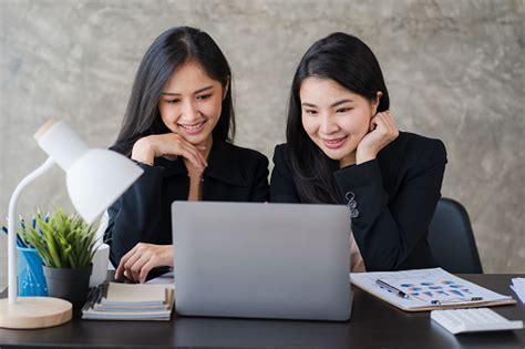 노트북 컴퓨터에서 일하는 두 명의 아시아 비즈니스 여성 펜을 들고 사무실 팀워크 및 고객 관리 개념 온라인 회의에서 화면을