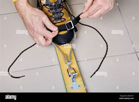 Installer Adjusts Strapon On Bracket While Mounting Free Heel Cable Ski