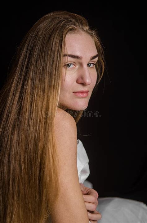 Portrait Of Beautiful Slender Young Woman With Blonde Hair In A White