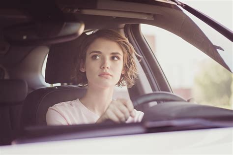 매력적인 예쁜 여성 진정 농축 얼굴 손 잡고 스티어링 휠 드라이브 자동차 조심스럽게 다른 드라이버가 실내에서 흰색 셔츠를 입고