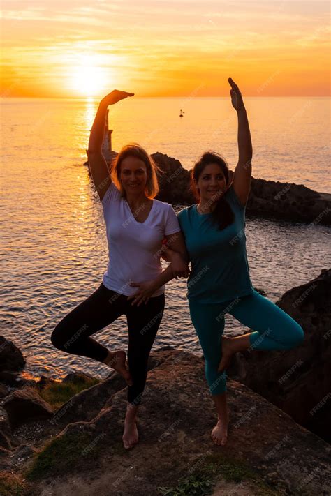 Premium Photo Vrksasana Two Women Doing Meditation And Yoga On A Rock