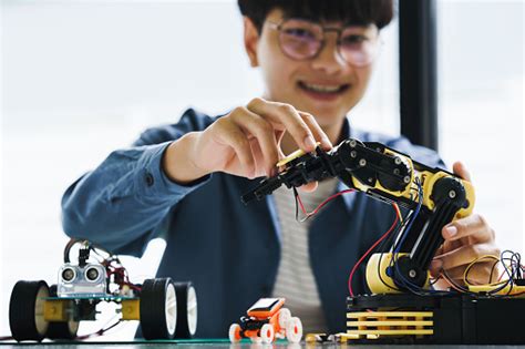 아시아 십대 학생들은 집에서 로봇 팔과 로봇 자동차 숙제 프로젝트를 하거나 놀고 회로를 분해하고 코딩합니다 로봇 공학 및 Stem 교육 개념의 기술 16 17 살에 대한