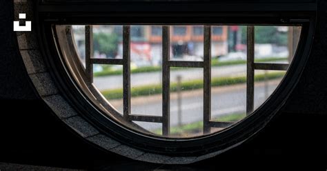 A Round Window Frames City Views With Bars Photo Free Wall Image On