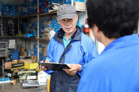 동네 카센터에서 고객에게 차트를 들고 자동차의 수리과정을 설명하며 응대하는 엔지니어 Foto De Stock Adobe Stock