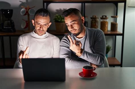 Homosexual Couple Using Computer Laptop Showing Middle Finger Impolite And Rude Off Expression