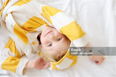 목욕 가운을 입은 귀여운 아이의 초상화가 깨어난 후 침대에 누워 있다 가정용 아동복 아침 일과를 보내고 유치원에 갈 준비를하는 소년 아기에 대한 스톡 사진 및 기타 이미지