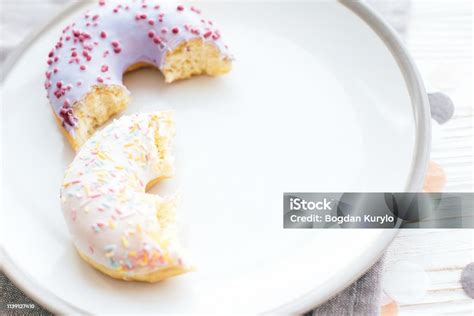 색종이와 흰색 테이블에 세련 된 접시에 화려한 뿌리 도넛의 맛 있는 물린 파티 개념입니다 다이어트 없음 웨딩 리셉션에서 캔디 바 보라색과 노란색 도넛 개념에 대한 스톡 사진