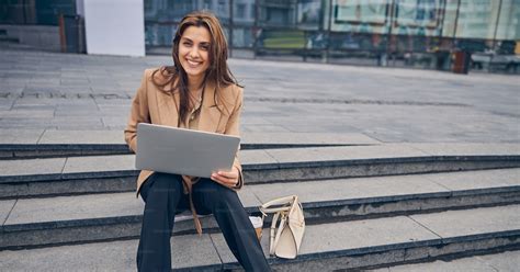 노트북을 들고 카메라를 향해 웃고 있는 활기찬 젊은 비즈니스 여성의 전면 모습 사진 Unsplash의 앉아 이미지