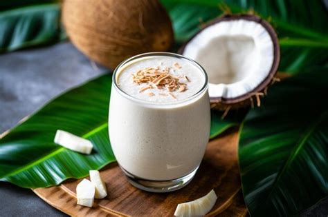 Cocktails Served In Coconut Shells By A Pool Premium Ai Generated Image