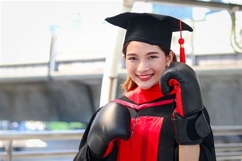 행복한 미소 졸업 한 여자 학생 온난화 광장 학술 모자 모자 빨간 권투 장갑 또는 미트 펀치 삶에 대한 은유 인생은 졸업식 날에 성공적인 교육을 축하 한 후 영토를위한