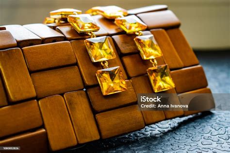 아름 답 고 유행 보석 및 여성을 위한 액세서리입니다 어둠에 사각형 돌과 나무와 노란 주황색 돌 질감 배경 골드 금속 기지에 겨자 밝은 스톤 보석 개인 장식품에 대한 스톡