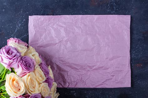 어두운 배경에 신선한 놀라운 흰색과 보라색 장미와 크래프트 종이 시트의 꽃다발 휴일 어머니의 선물 발렌타인 데이 생일 기념일과