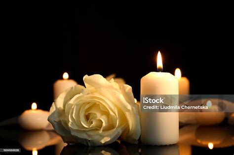 하얀 장미와 불타는 촛불은 어둠 속에서 검은 거울 표면에 있고 텍스트를 위한 공간이 있는 클로즈업 장례식 상징 촛불 조명 장비에 대한 스톡 사진 및 기타 이미지 Istock