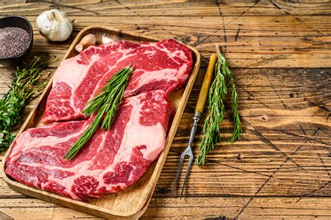 신선한 생 블랙 앵거스 프라임 쇠고기 척 아이 롤 스테이크 나무 배경 맨 위 보기입니다 복사 공간 검은색에 대한 스톡 사진 및