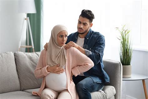 Caring Arab Husband Making Neck Massage To Pregnant Muslim Wife At Home Stock Image Image Of