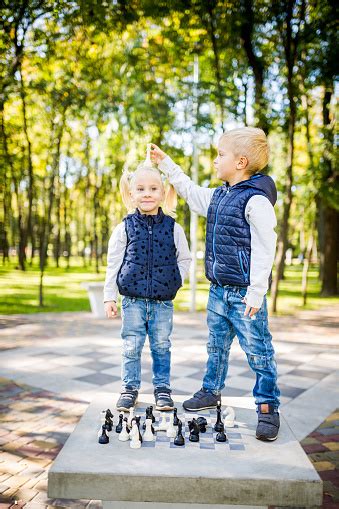 공원에서 함께 체스를 재생 재미있는 소년과 소녀 아이들을위한 체스 클럽 행복한 어린 시절과 아이들의 우정 뇌 발달을위한 논리