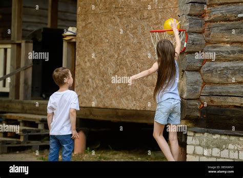 brother and sister playing basketball in backyard throwing ball into
