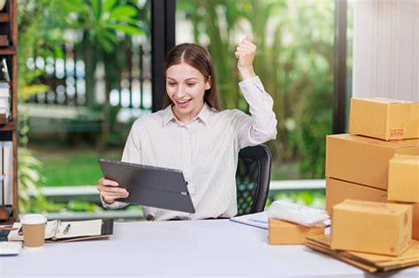 소포 배달 및 온라인 판매의 개념 소매업체 계산기를 사용하여 소포 상자에 포장하기 위해 온라인 상점에서 당일 판매를 계산하고 고객에게 제품을 보낼 준비를 합니다 25 29