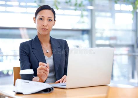 Getting Work Done A Young Ethnic Businesswoman Using Her Laptop Stock