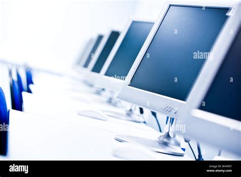 image of empty classroom with computers tables and chairs in the lines