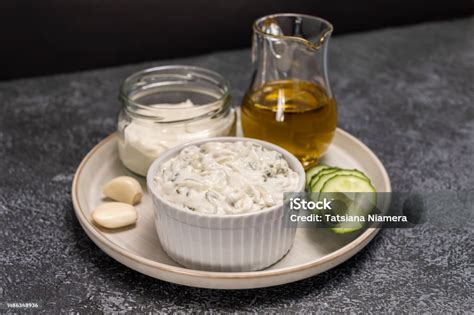 전통적인 그리스 요구르트 소스 Tzatziki 흰 그릇에 드레싱 강판 오이 사워 크림 요구르트 올리브 오일 마늘 짙은 회색