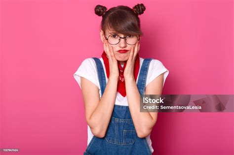 푸 티 입술을 가진 색다른 불행 한 십 대 소녀의 초상화 모든 것을 불쾌 하 게 하는 뺨에 손을 유지 좌절 느낌과 화가 분홍색 배경 위에 포즈 모델 텍스트에 대 한 공간을