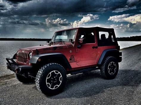 Red Jeep Wrangler Parked By The Water