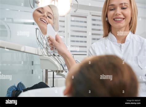 Client Of Dentistry Clinic Lying On Dentist Chair And Looking At