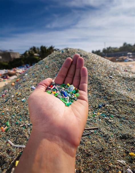 Premium Photo Microplastic On Hand With Pile Of Microplastics On The