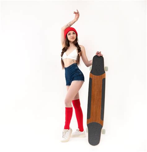 Premium Photo Sexy Girl In A Fashionable Red Hat With A Longboard On A White Background