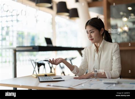 Attractive Asian Business Woman Working With A Laptop And Financial Document At Office