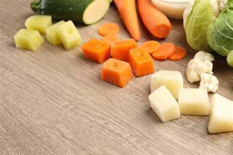 Different Frozen Purees Cubes And Fresh Vegetables On Wooden Table