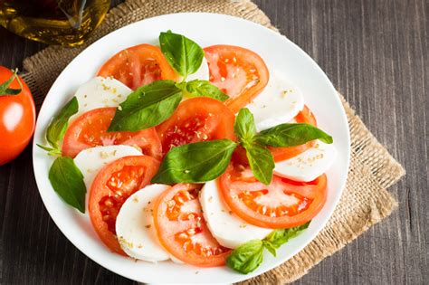 잘 익은 토마토 바 질 버팔로 모 짜 렐 라 치즈를 곁들인 카프 라스 샐러드의 클로즈업 사진 이탈리아와 지중해 음식 개념입니다 신선 하 고 건강 한 유기농 식사 스타터와