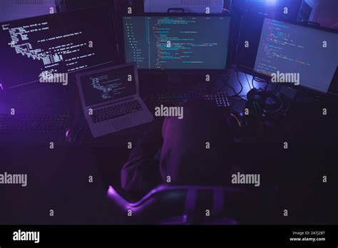 Top View At Unrecognizable Cyber Security Hacker Wearing Hood While Working On Programming Code