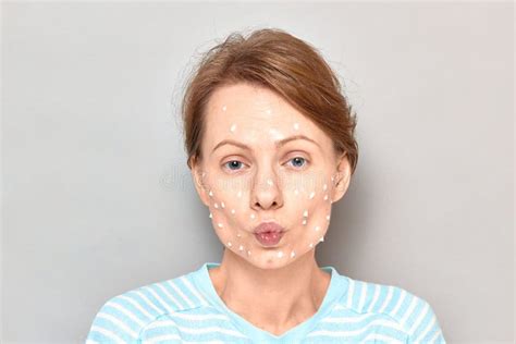 Portrait Of Funny Flirty Girl With White Drops Of Face Cream On Skin