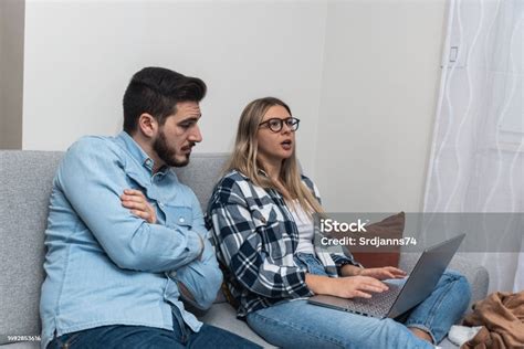 젊은 행복한 사랑스러운 커플은 집에서 함께 예산을 계획하고 노트북 컴퓨터에 메모를 쓰고 쇼핑을 위한 체크리스트나 청첩장을 위한 하객 목록을 만들고 예식에서 의자를 세고 있다