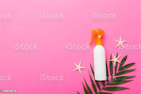 자외선 차단제 스프레이 병 태양 보호 크림과 색상 배경에 열대 녹색 잎이있는 바다 껍질이있는 병 상단 전망 개념에 대한 스톡