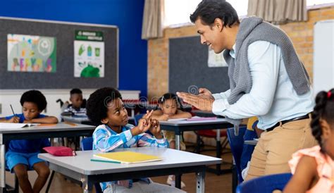 Diverse Male Teacher Teaching School Boy Using Sign Language In Class