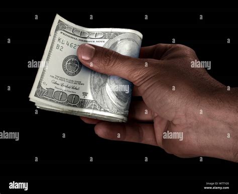 A Black Male Hand Handing Over A Wad Of Folded Us Dollar Bank Notes On